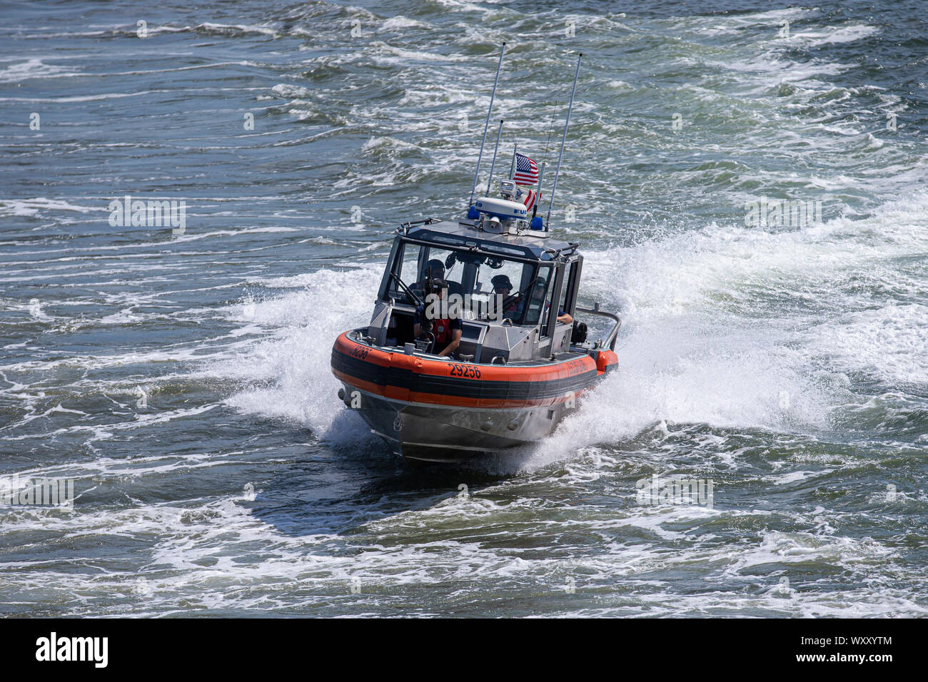 A Coast Guard vessel on patrol following the Staten Island Ferry in New ...