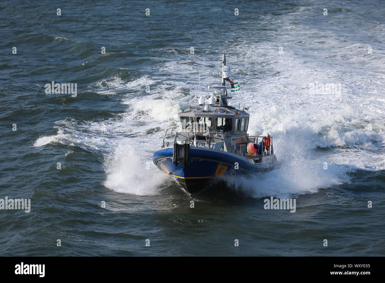 A NYPD boat on patrol following the Staten Island Ferry in New York ...