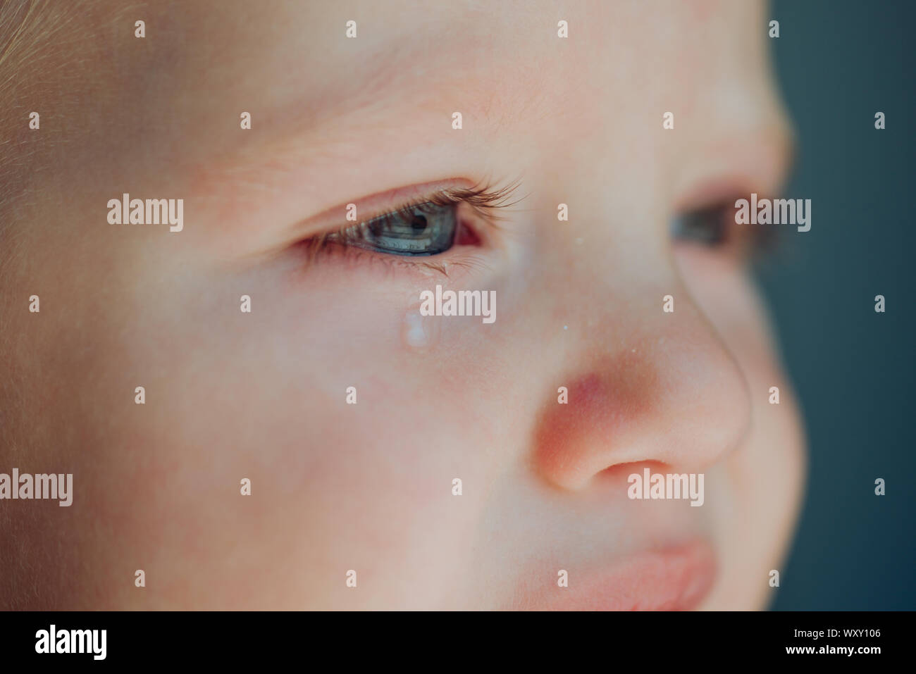 Small and unhappy. Little baby. Baby with tear rolling down his cheek ...