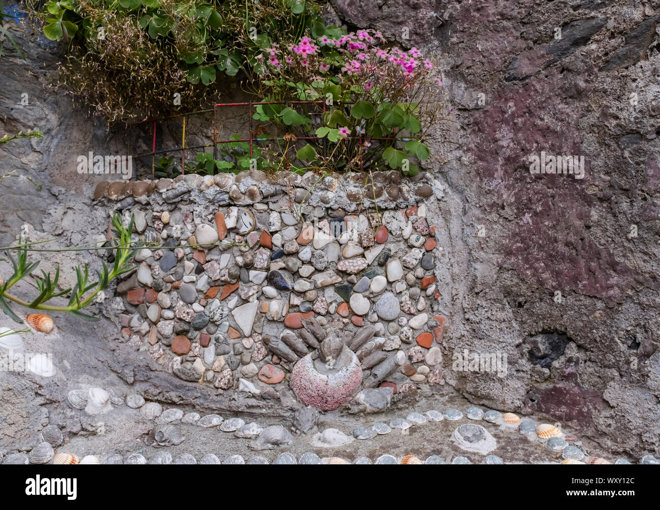 Seashells decorate a wall along a cliffside path in Vernazza, Italy ...