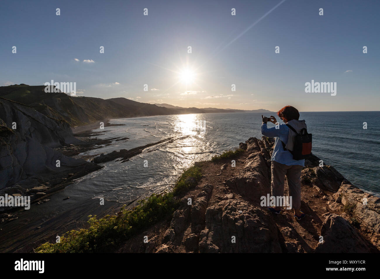 Tourist taking picture in a path to spectacular coastal scenery, Zumaia ...