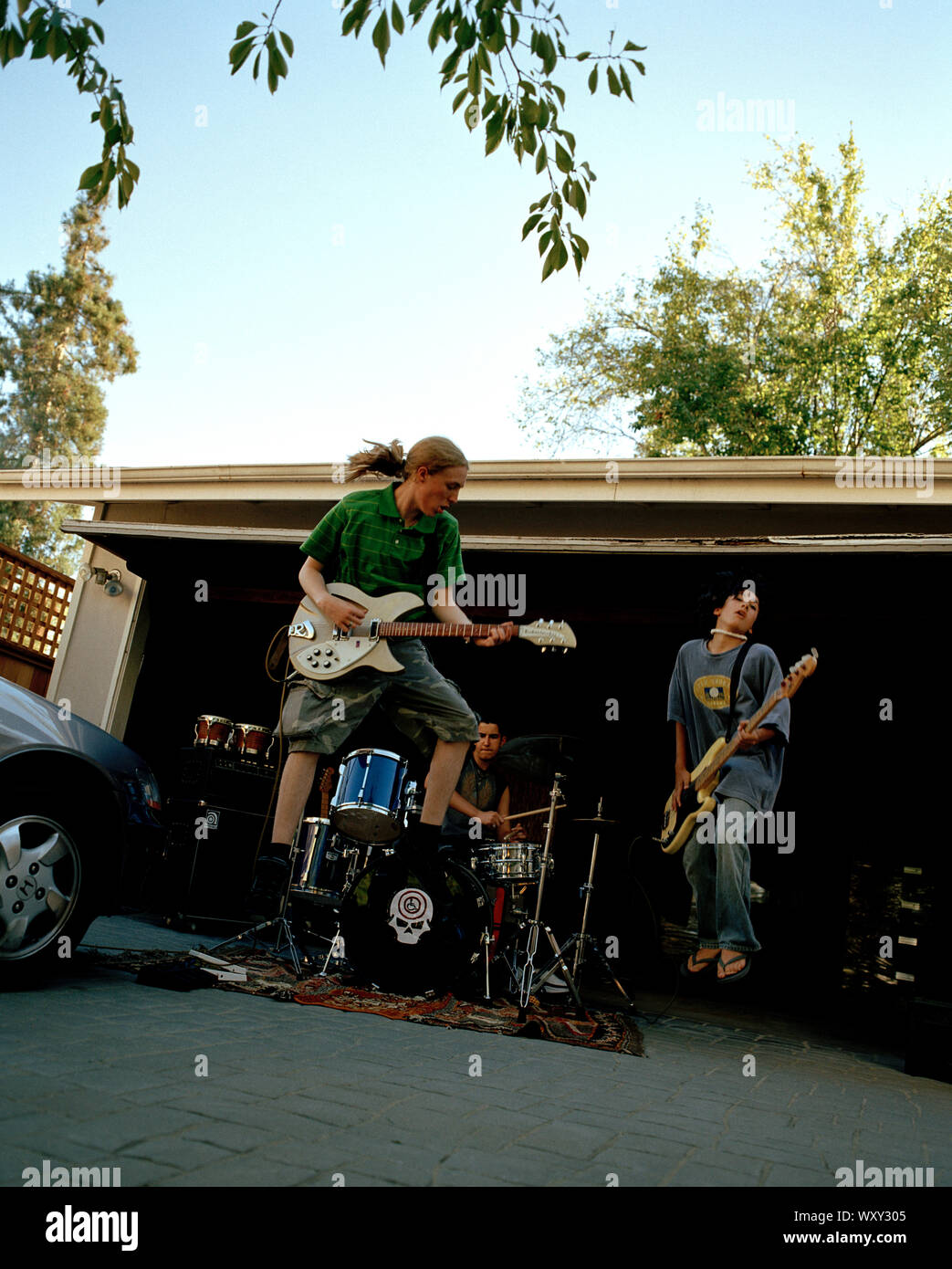 Three teenage boys having band practise in a suburban driveway Stock ...