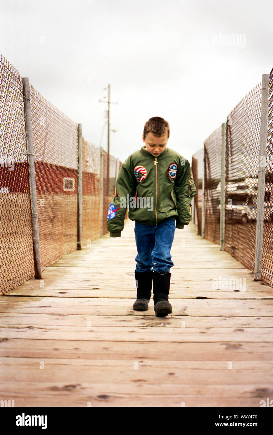 Boy walking on boardwalk Stock Photo - Alamy