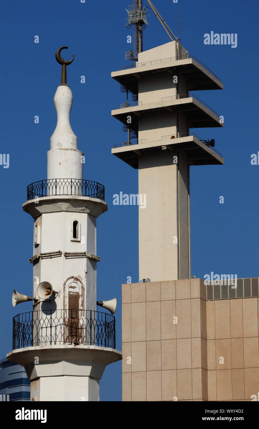 White minaret of a an old mosque with crescent is contrasted against ...
