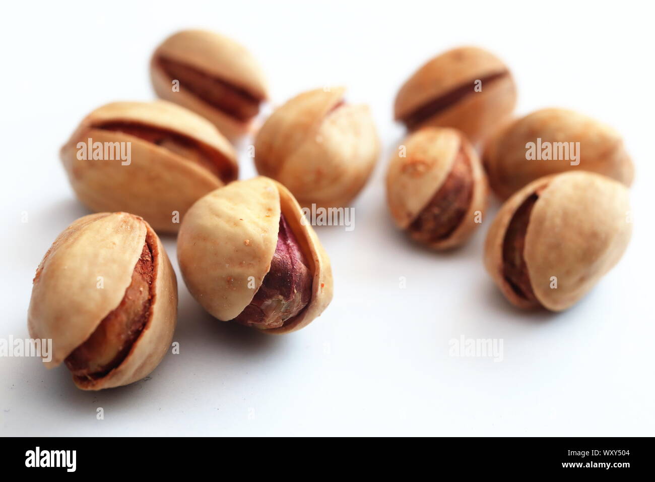 Brown roasted iranian pistachio nuts in shells on plain white hi-res ...