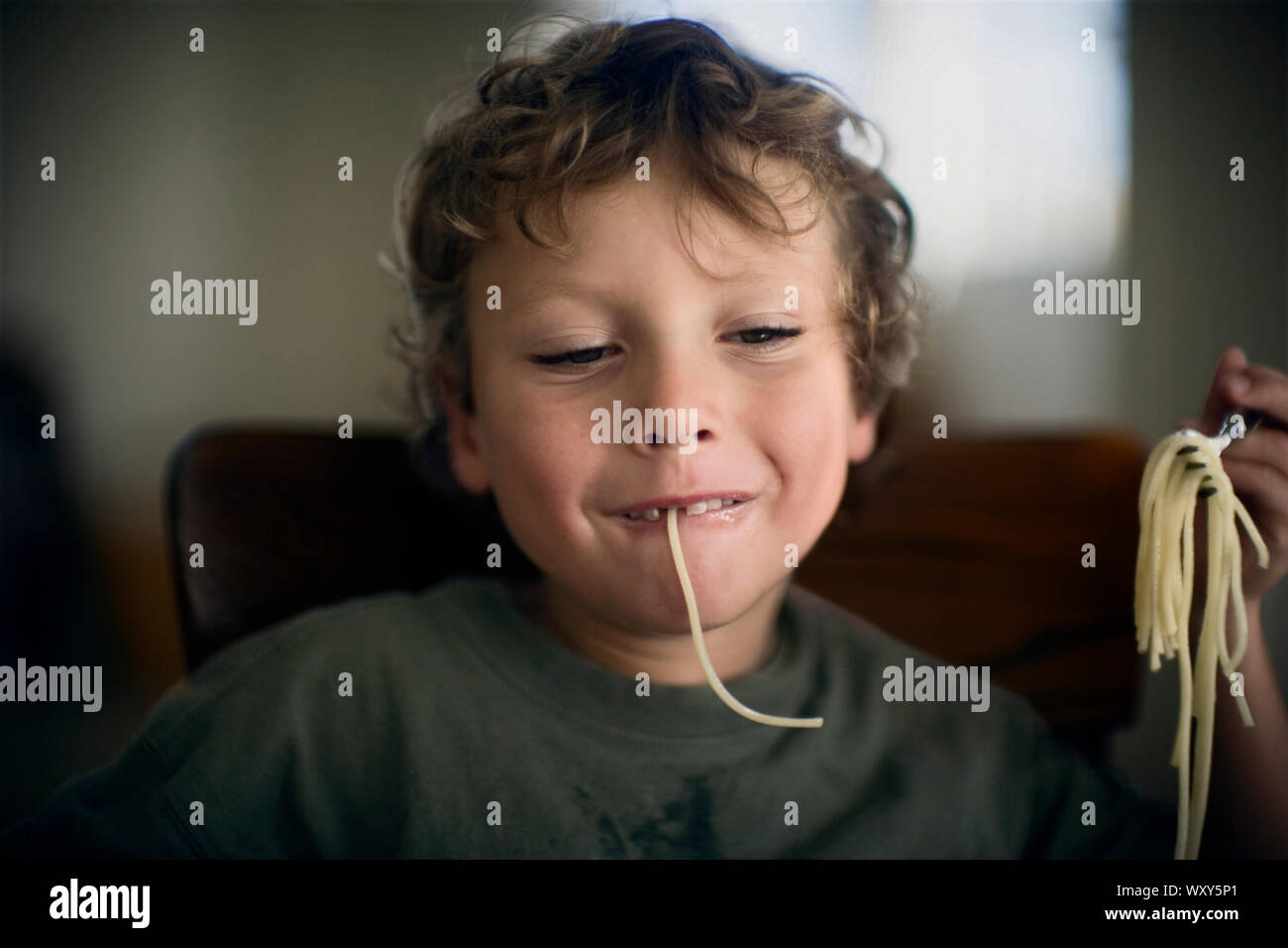 Boy eats spaghetti through gap in teeth Stock Photo - Alamy