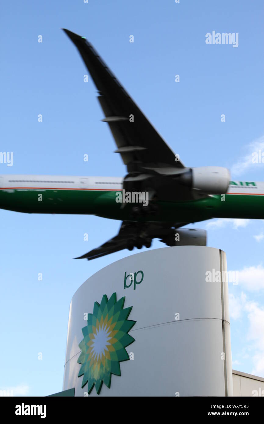 PASSENGER JET FLYING ABOVE A BP [ BRITISH PETROLIUM ] FUEL STATION NEAR ...