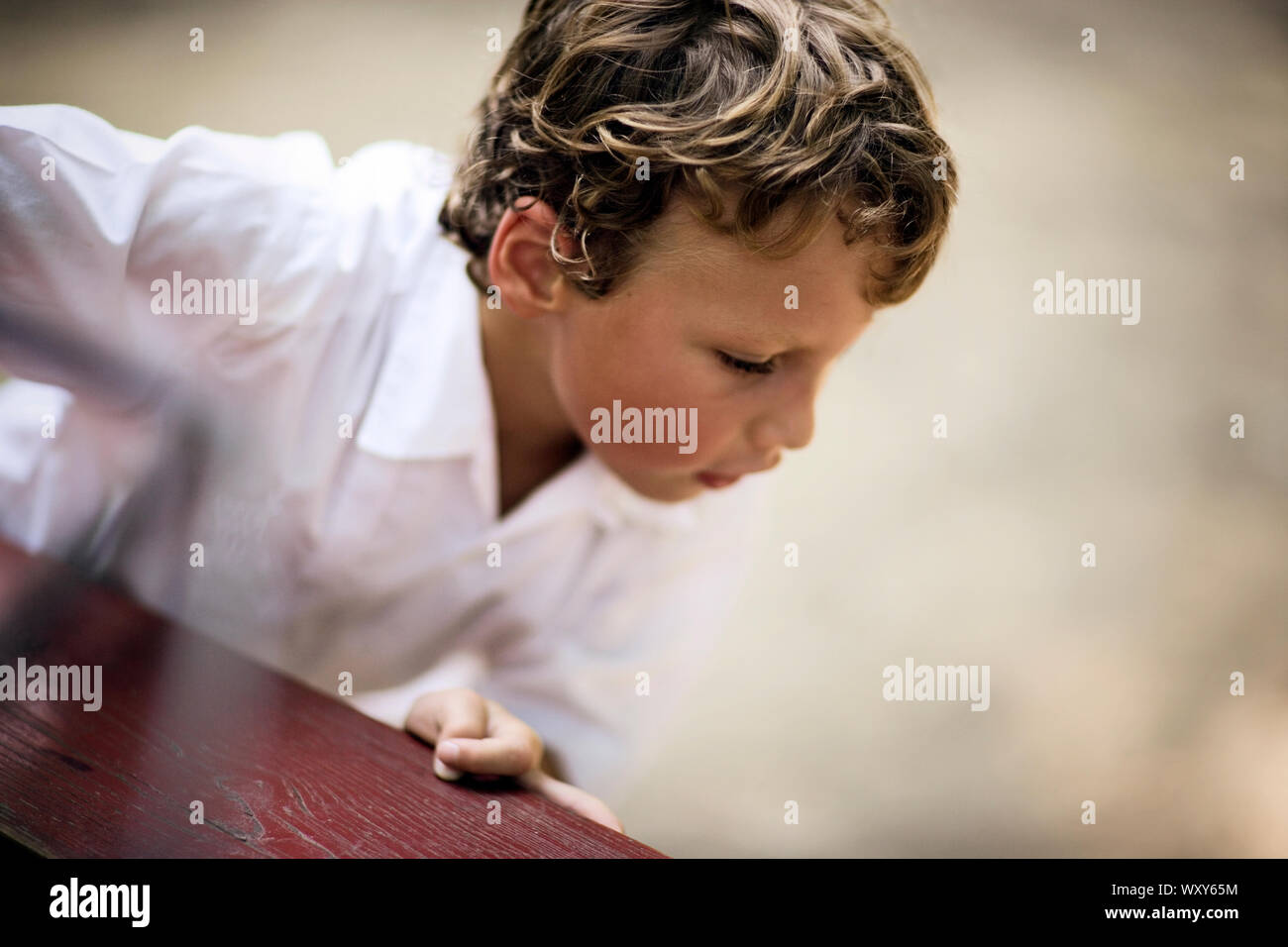 Side view of a small boy pushing the table Stock Photo - Alamy