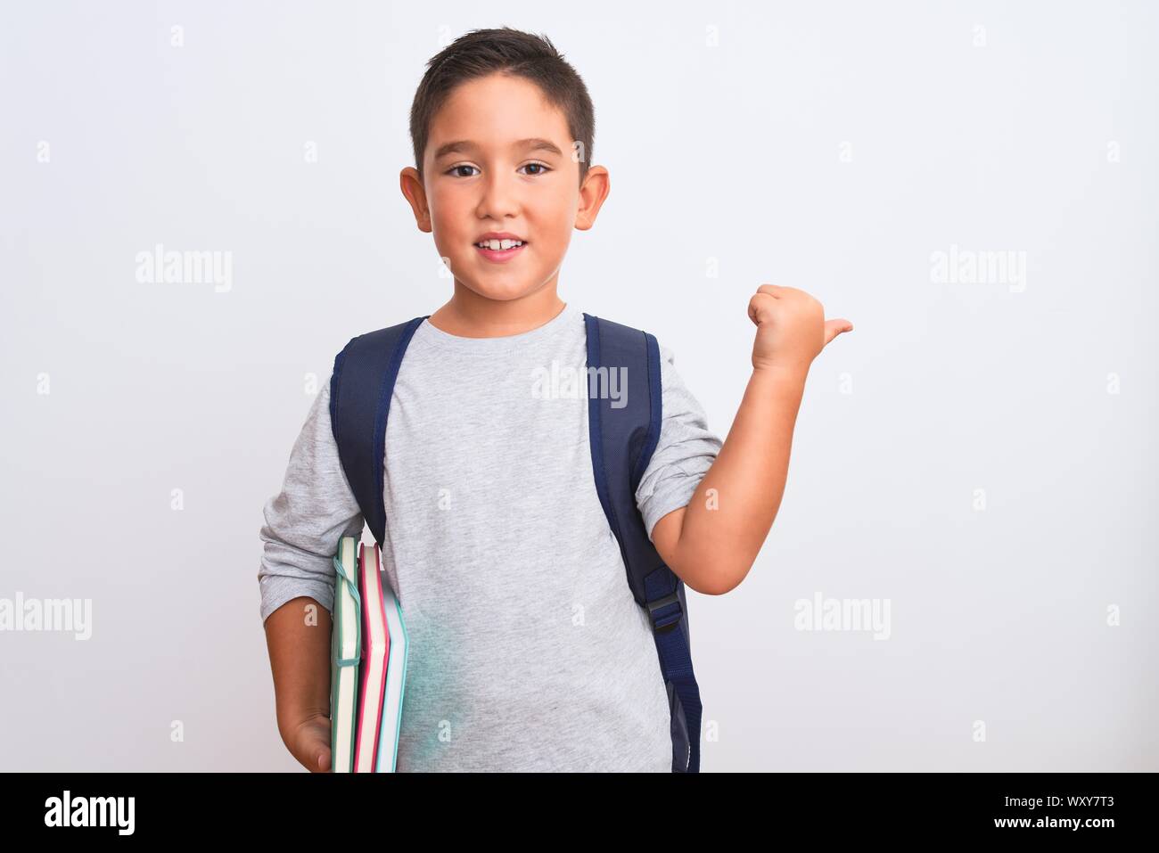 Beautiful student kid boy wearing backpack holding books over isolated ...