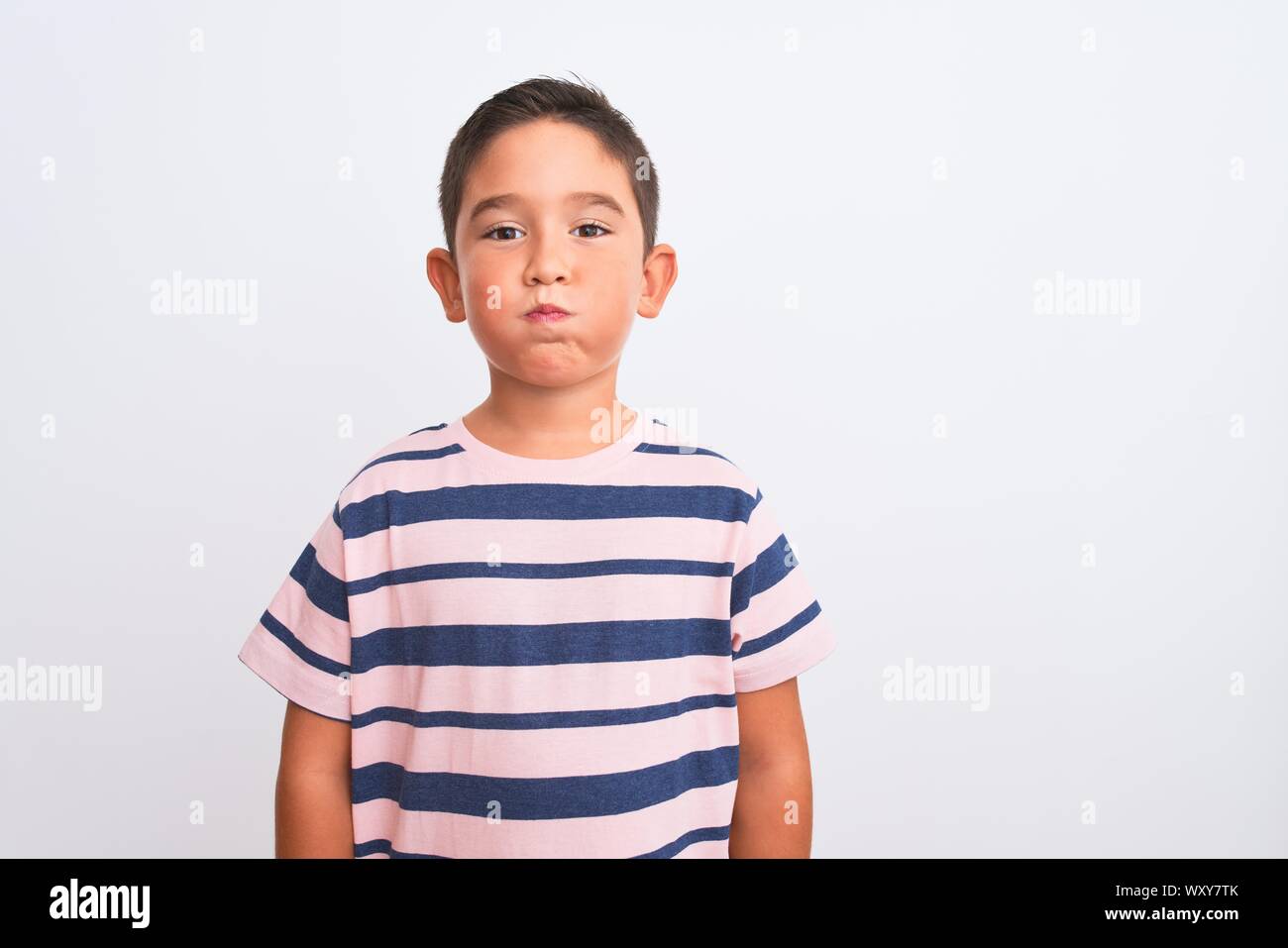 Beautiful kid boy wearing casual striped t-shirt standing over isolated ...
