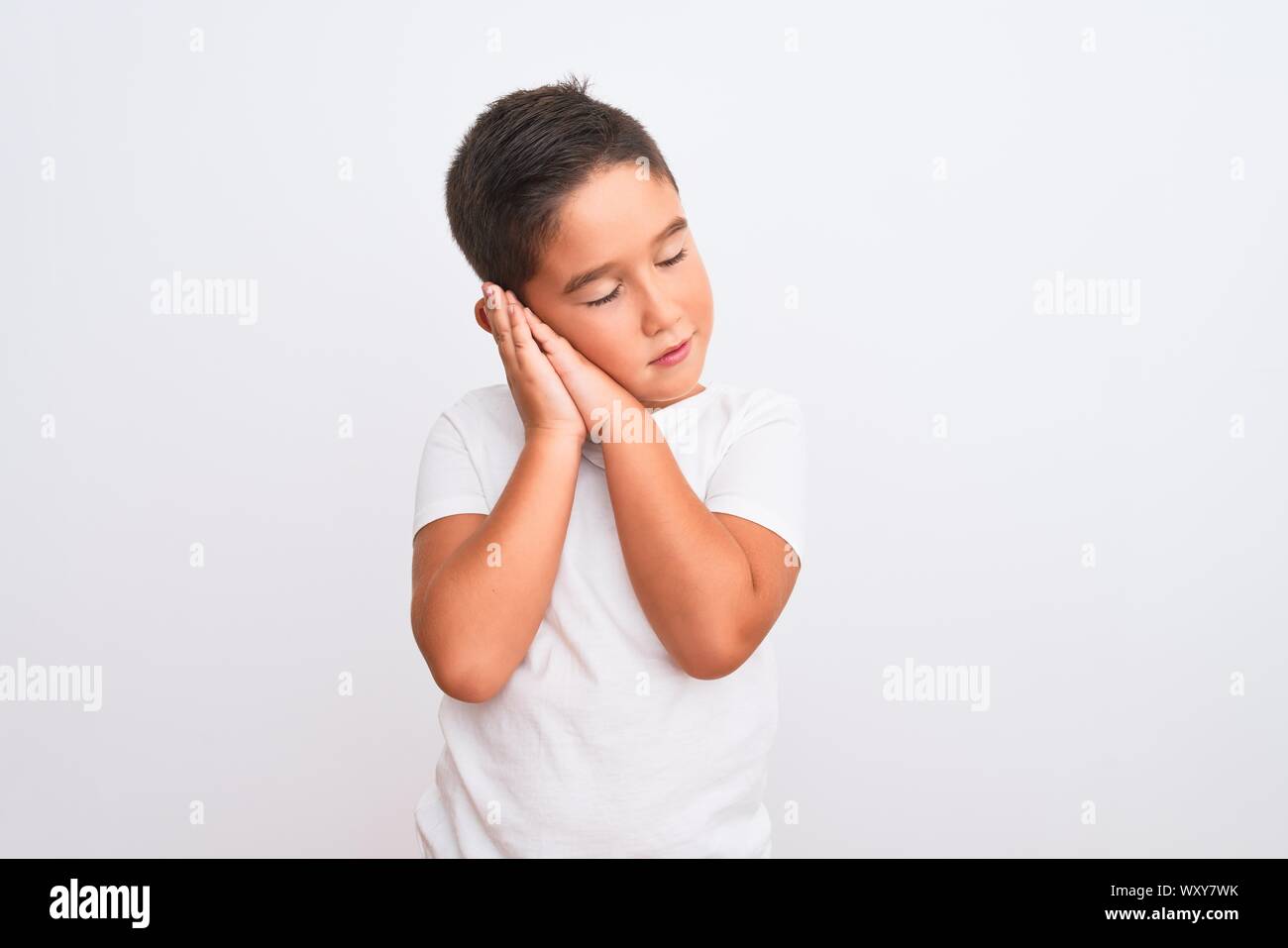 Beautiful kid boy wearing casual t-shirt standing over isolated white ...