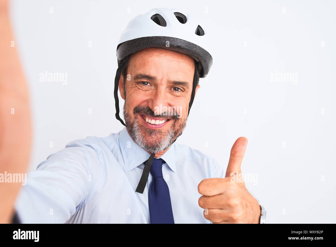 Middle age businessman wearing bike helmet make selfie over isolated ...