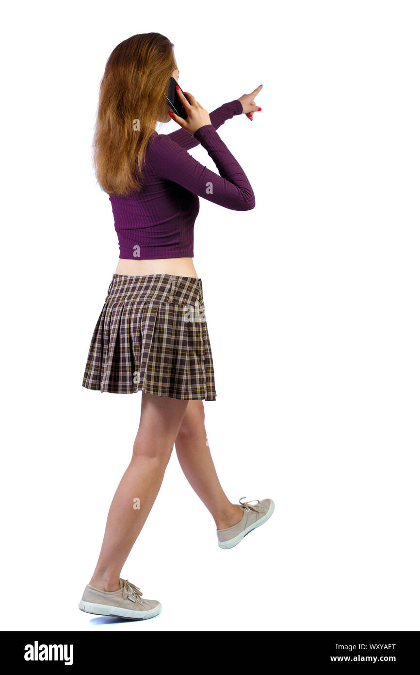 back view of walking woman. beautiful girl going, pointing and talking ...