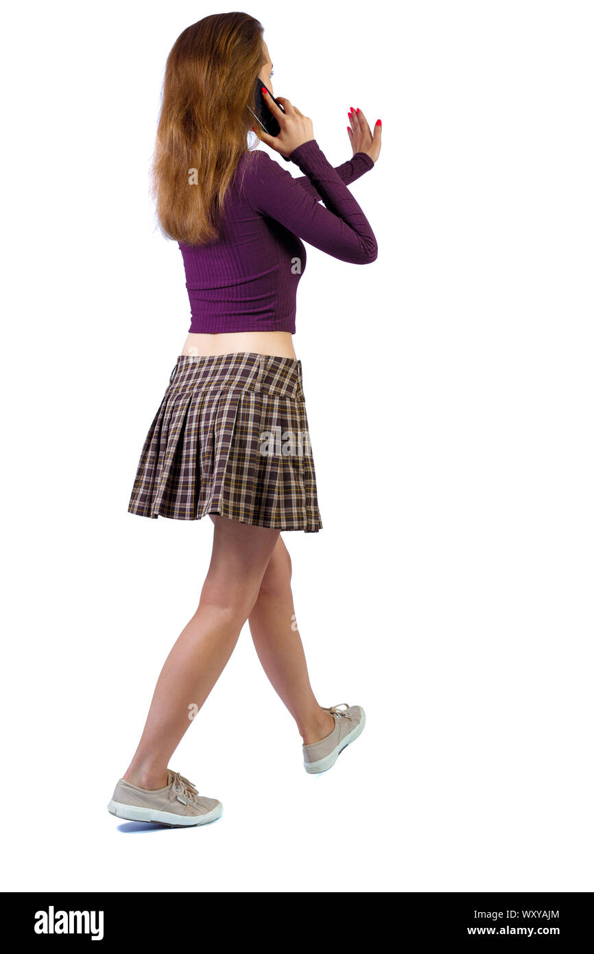 back view of walking woman. beautiful girl going, pointing and talking ...