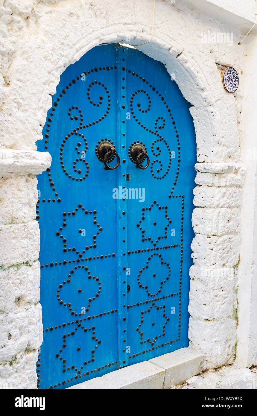 The ornate Arab style wooden door of bright blue color with Islamic ...