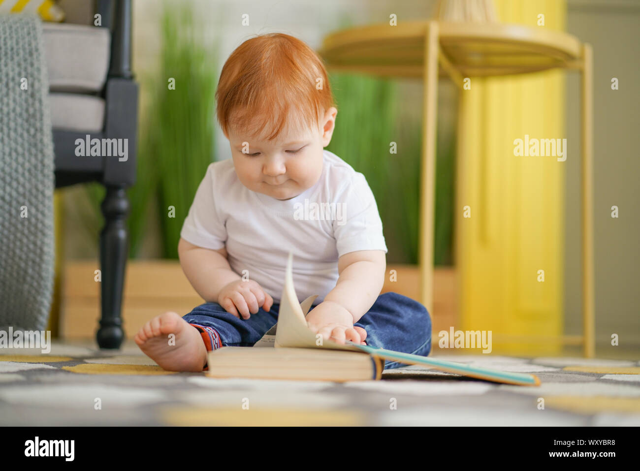 little infant Boy reading a book, educating concept Stock Photo - Alamy