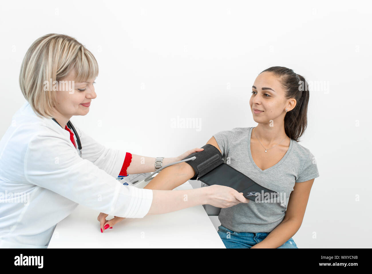 Professional female doctor putting on device for measuring pressure on ...