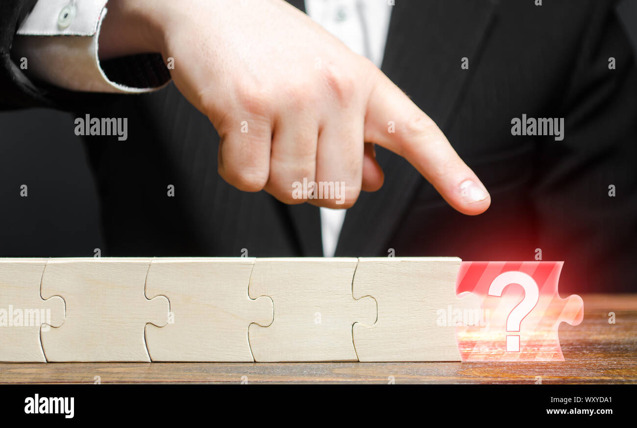 Businessman finger points to the absence of a component in the puzzle ...