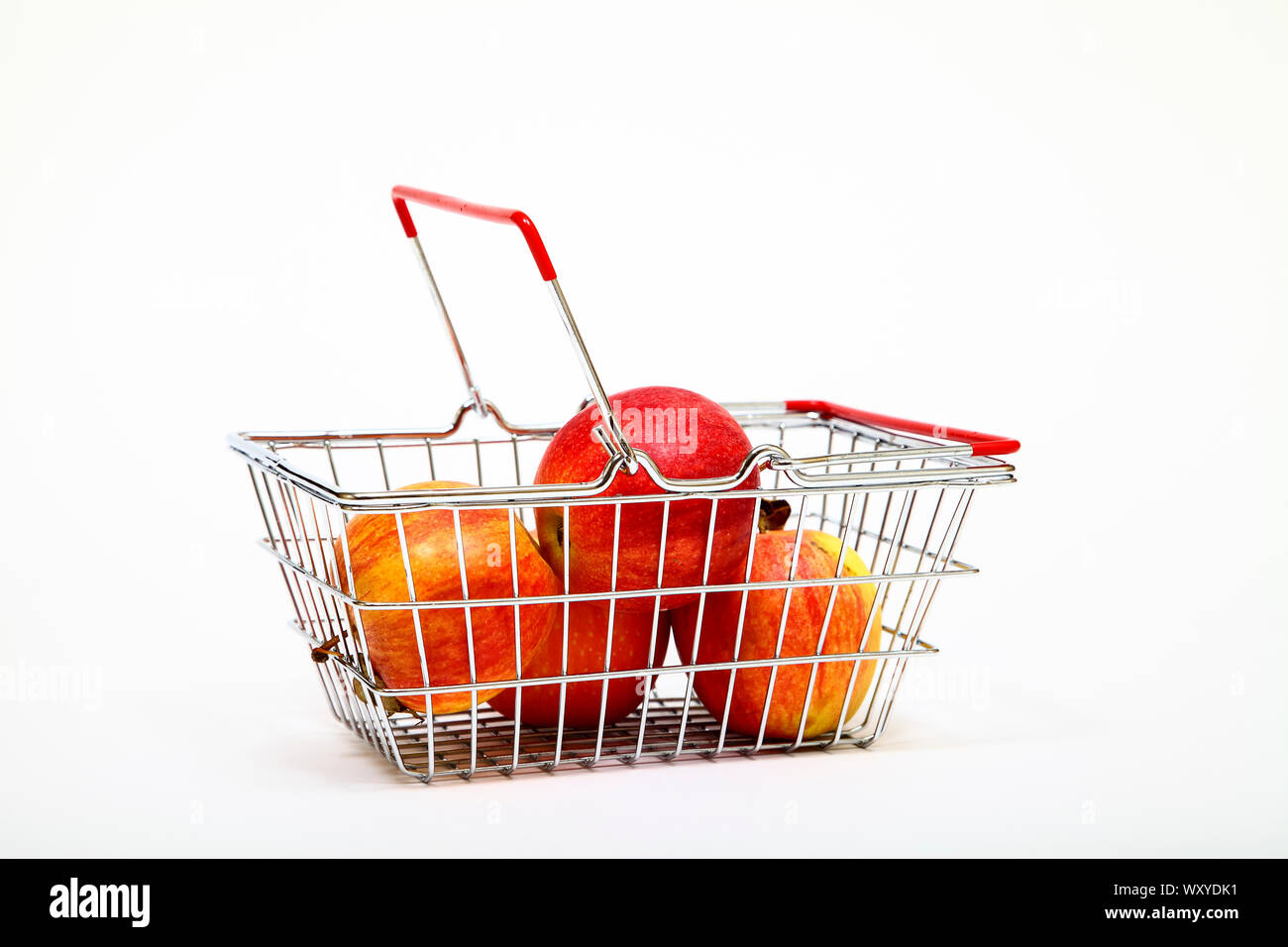 Miniature metal wire basket filled with ripe red eating apples isolated ...