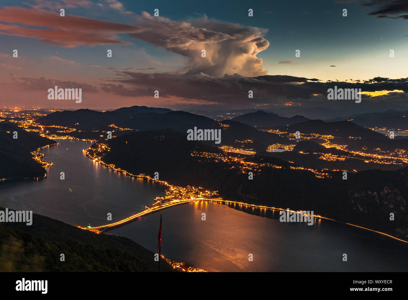 Panorama after sunset with city lights and bridge Diga di Melide over ...