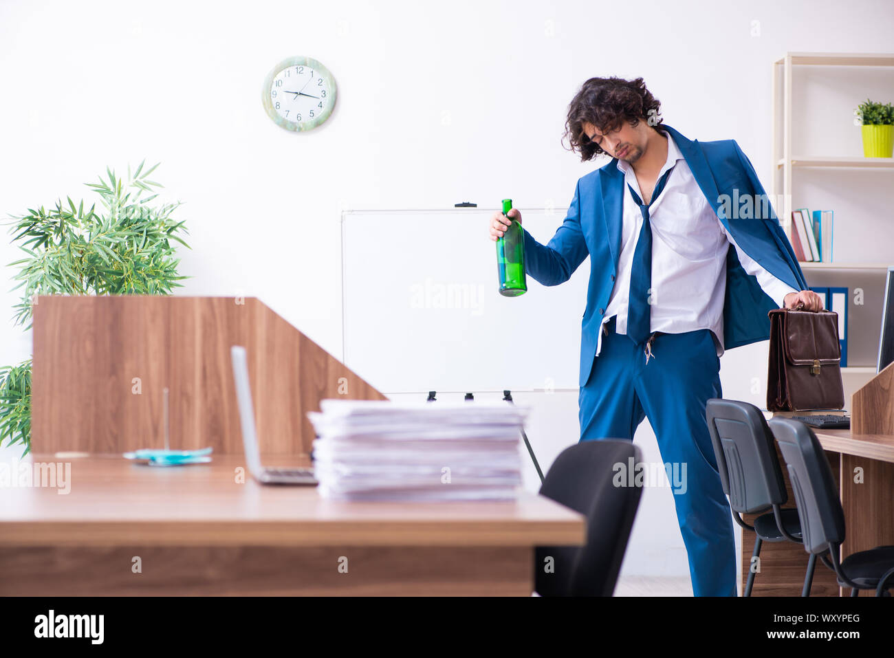 The young drunk employee in the office Stock Photo - Alamy