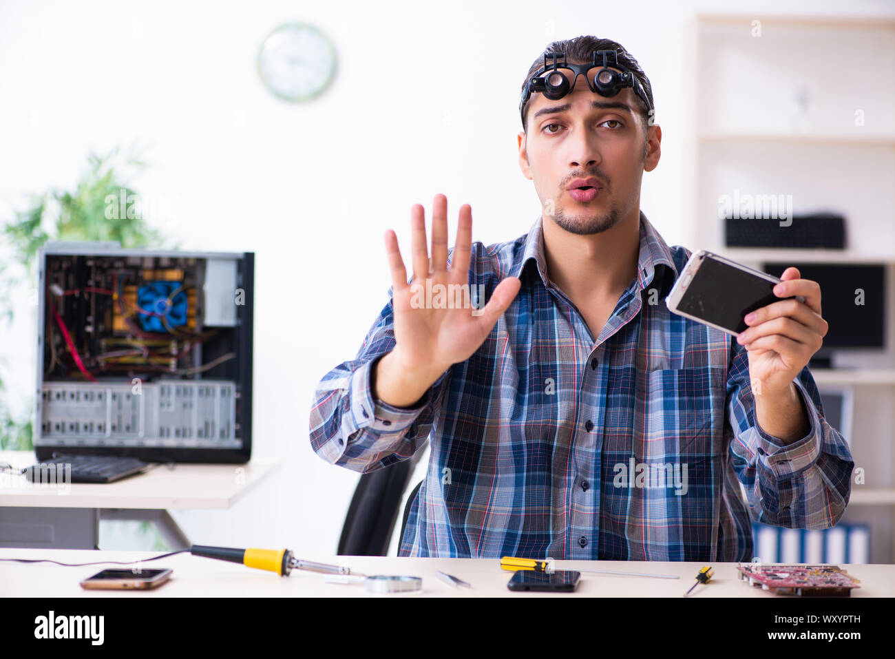 The young handsome technician repairing mobile phone Stock Photo - Alamy