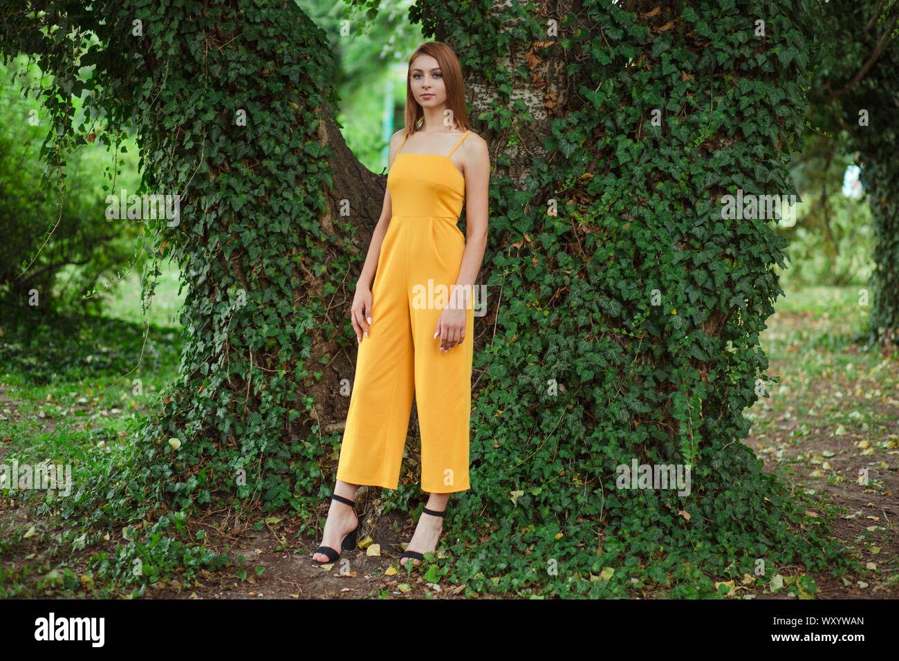 Cute Woman smiling standing posing in the garden near bushes and green ...