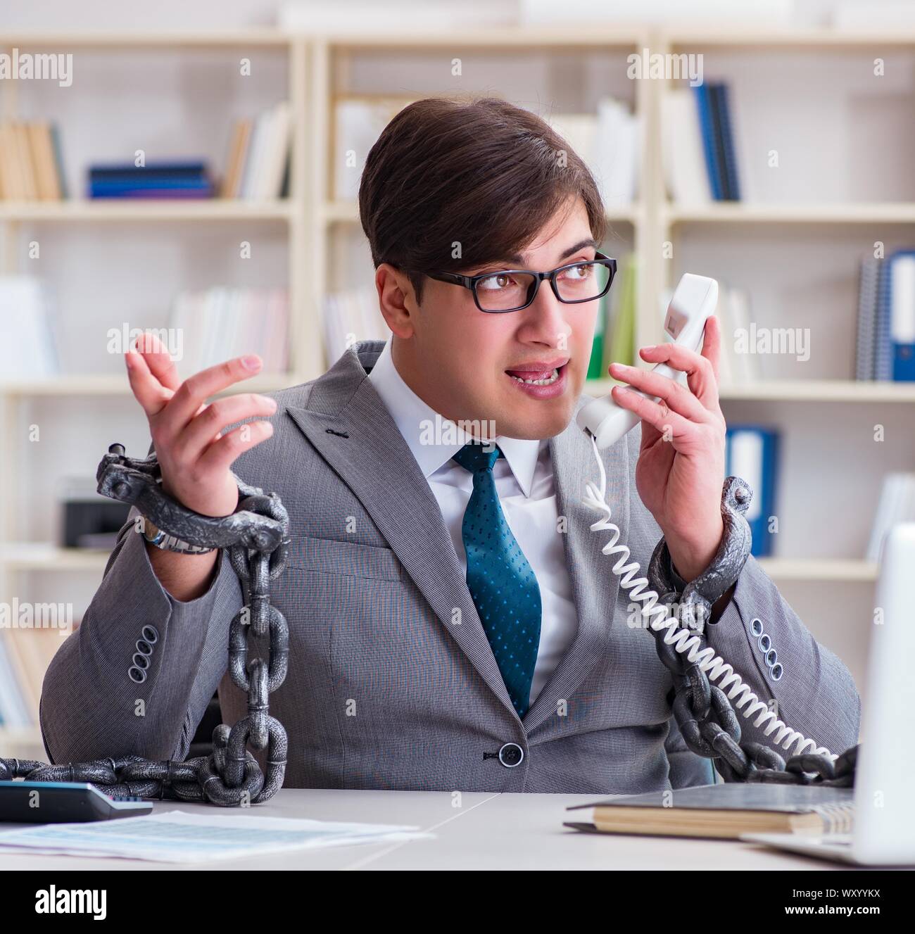 The businessman tied with chains to his work Stock Photo - Alamy
