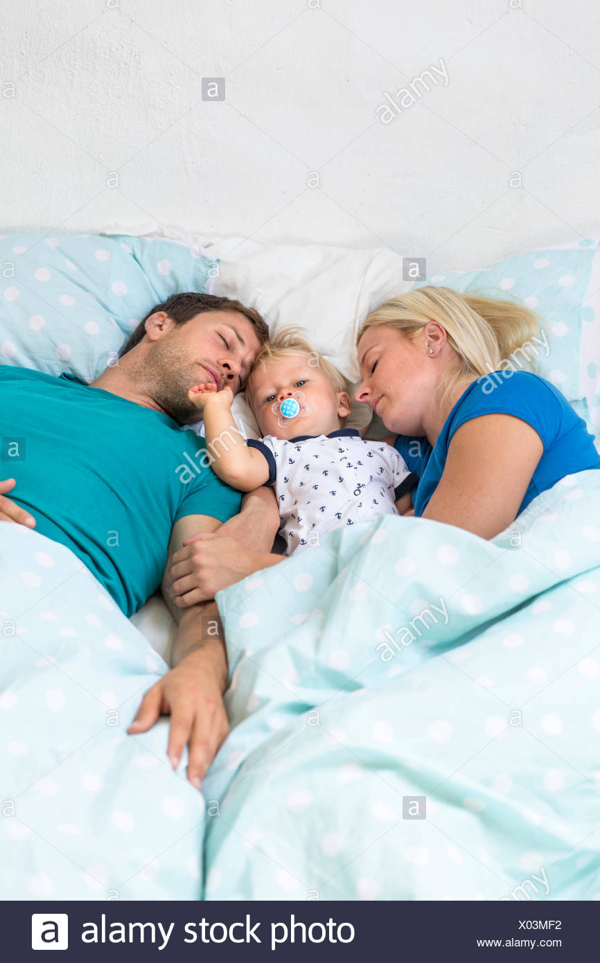 Family Of Three People Sleeping In One Bed Stock Photos & Family Of ...