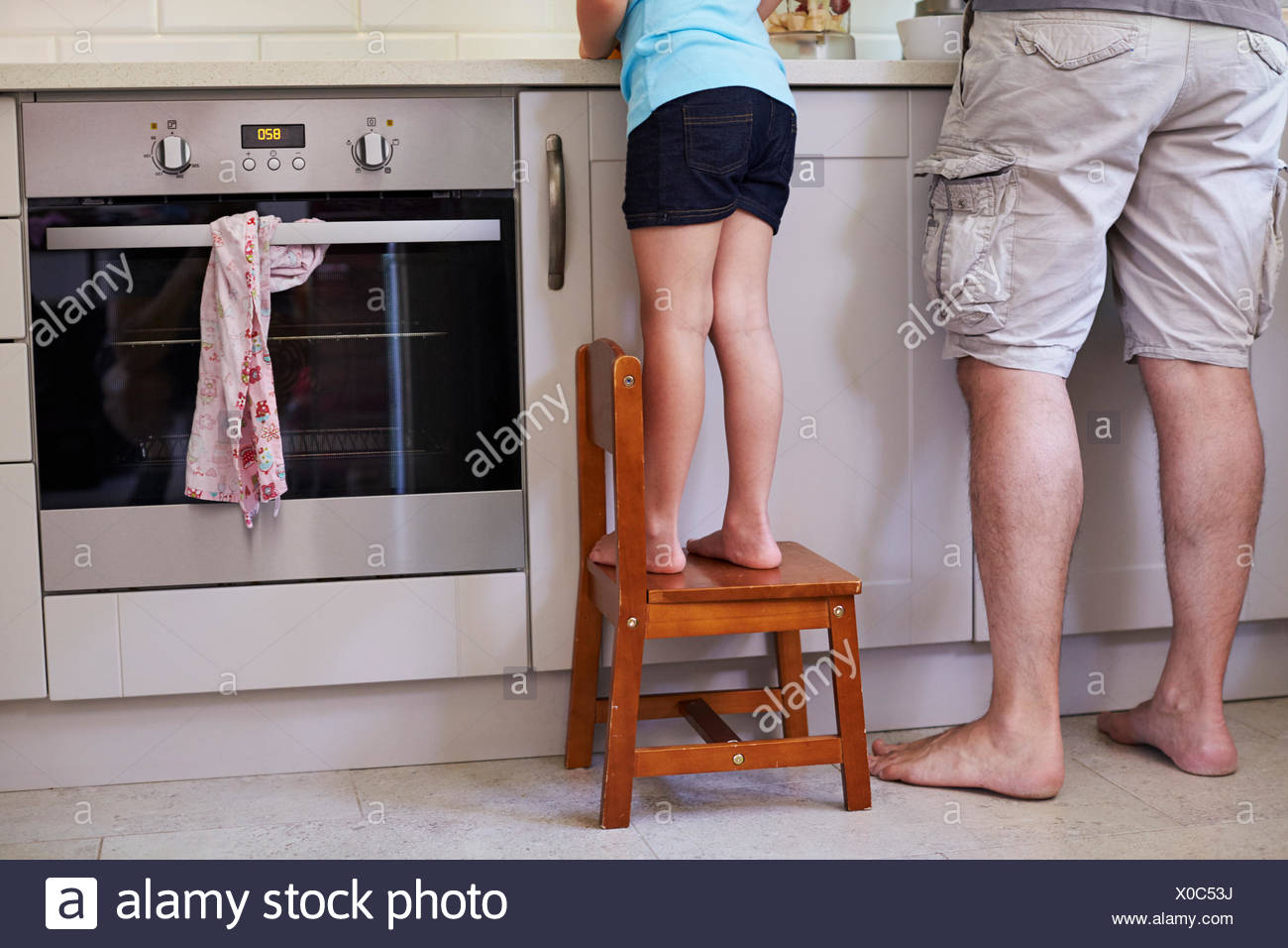 Girl Standing On Chair Reaching Stock Photos & Girl Standing On Chair ...