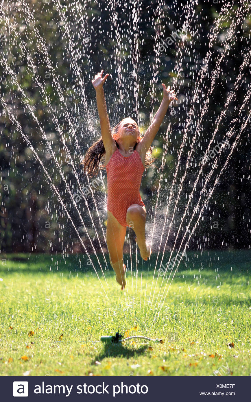 Girl Jumping Through Sprinkler High Resolution Stock Photography and ...