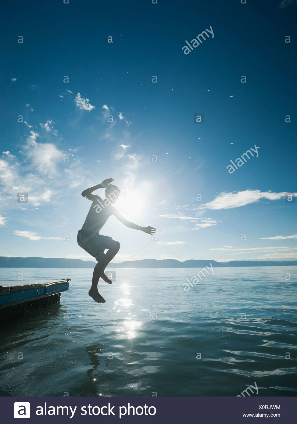 Children Jumping Into Water Silhouette Stock Photos & Children Jumping ...