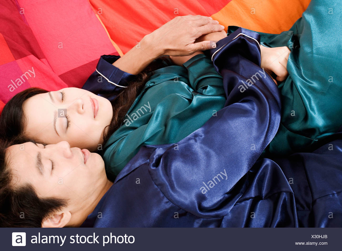 Asian Couple Cuddling On Bed Stock Photos & Asian Couple Cuddling On ...