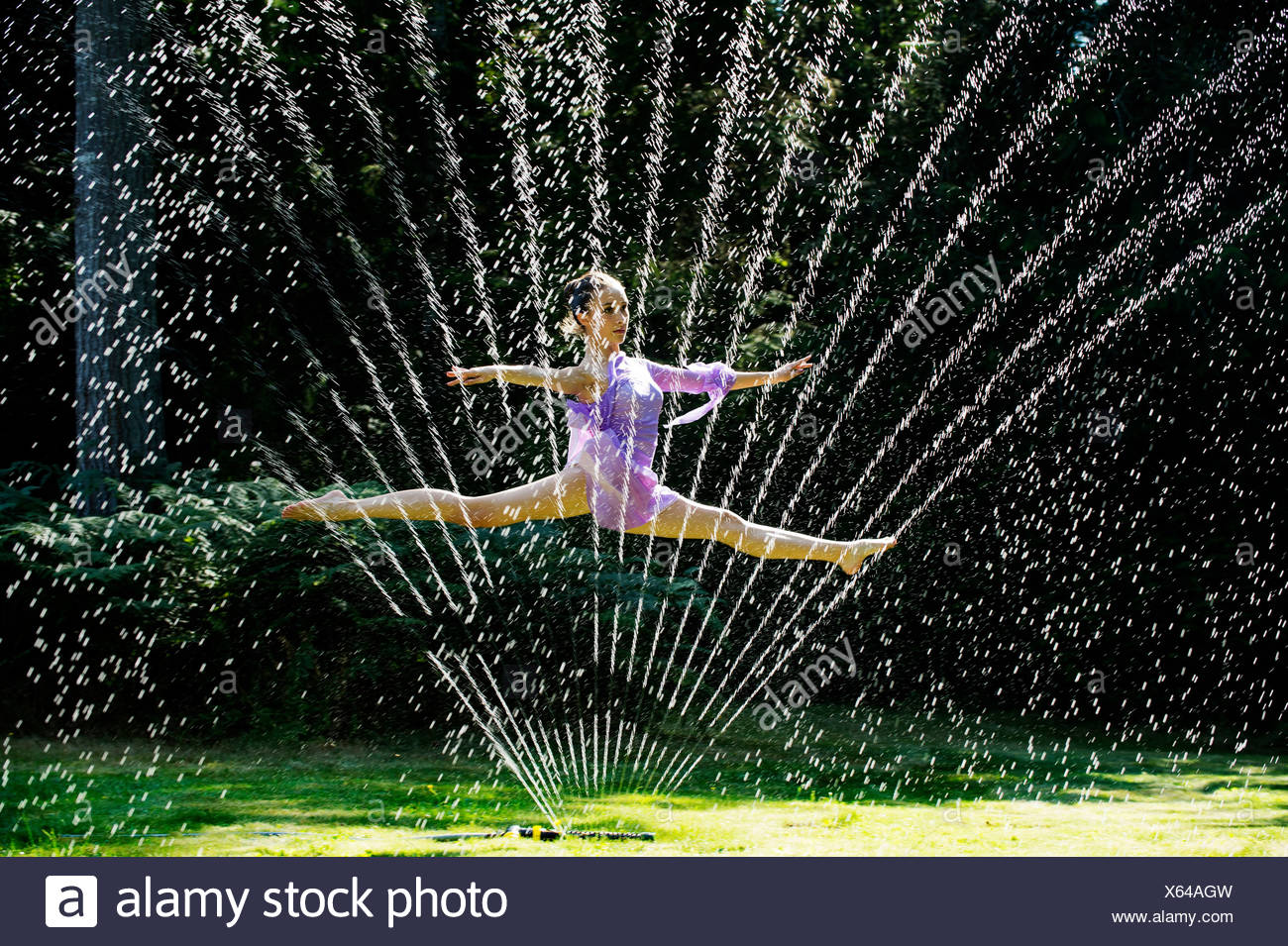Girl Jumping Through Sprinkler High Resolution Stock Photography and ...