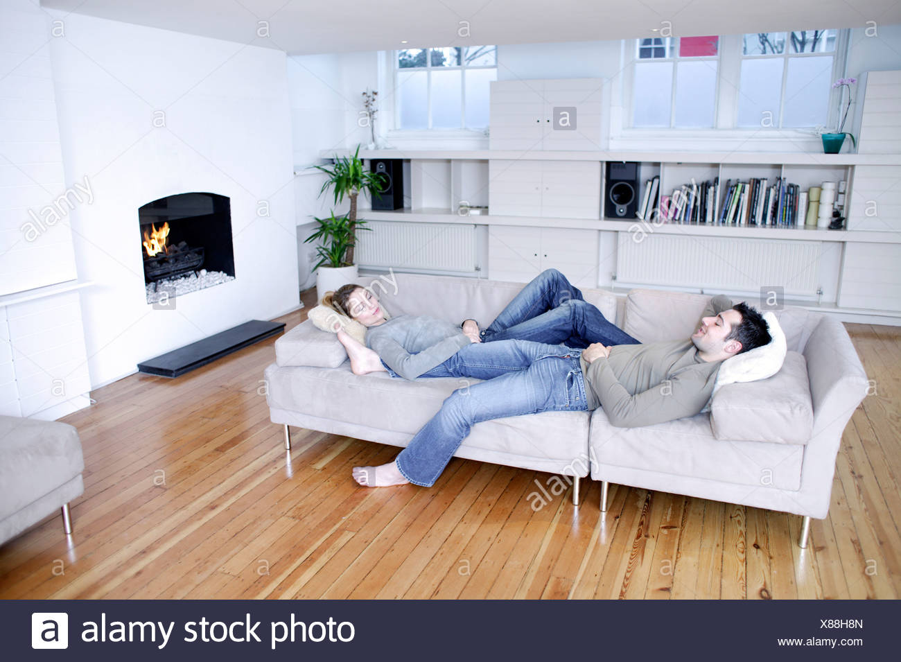 Young Couple Lying On Sofa Stock Photos & Young Couple Lying On Sofa ...