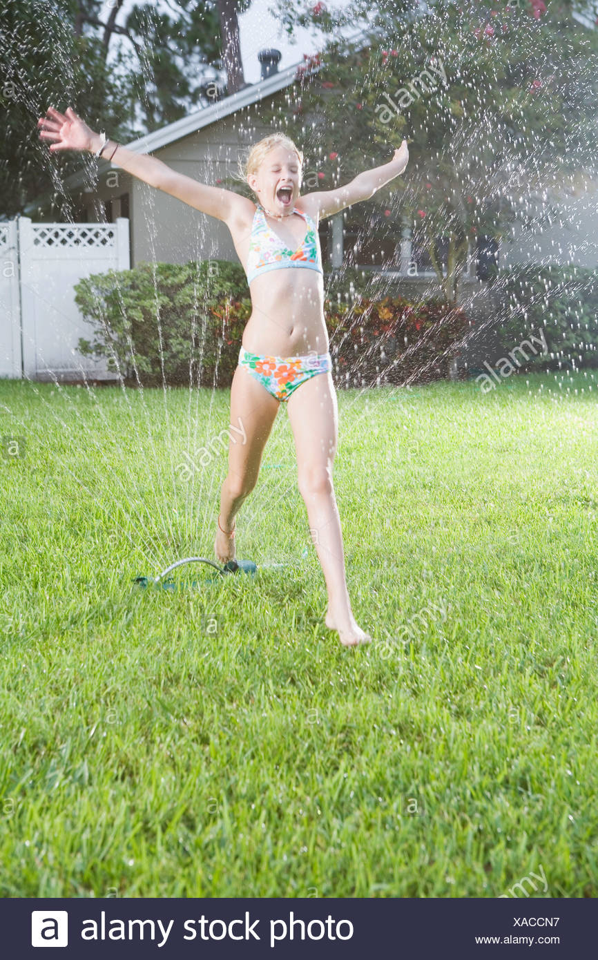 Girl Jumping Through Sprinkler High Resolution Stock Photography and Images - Alamy