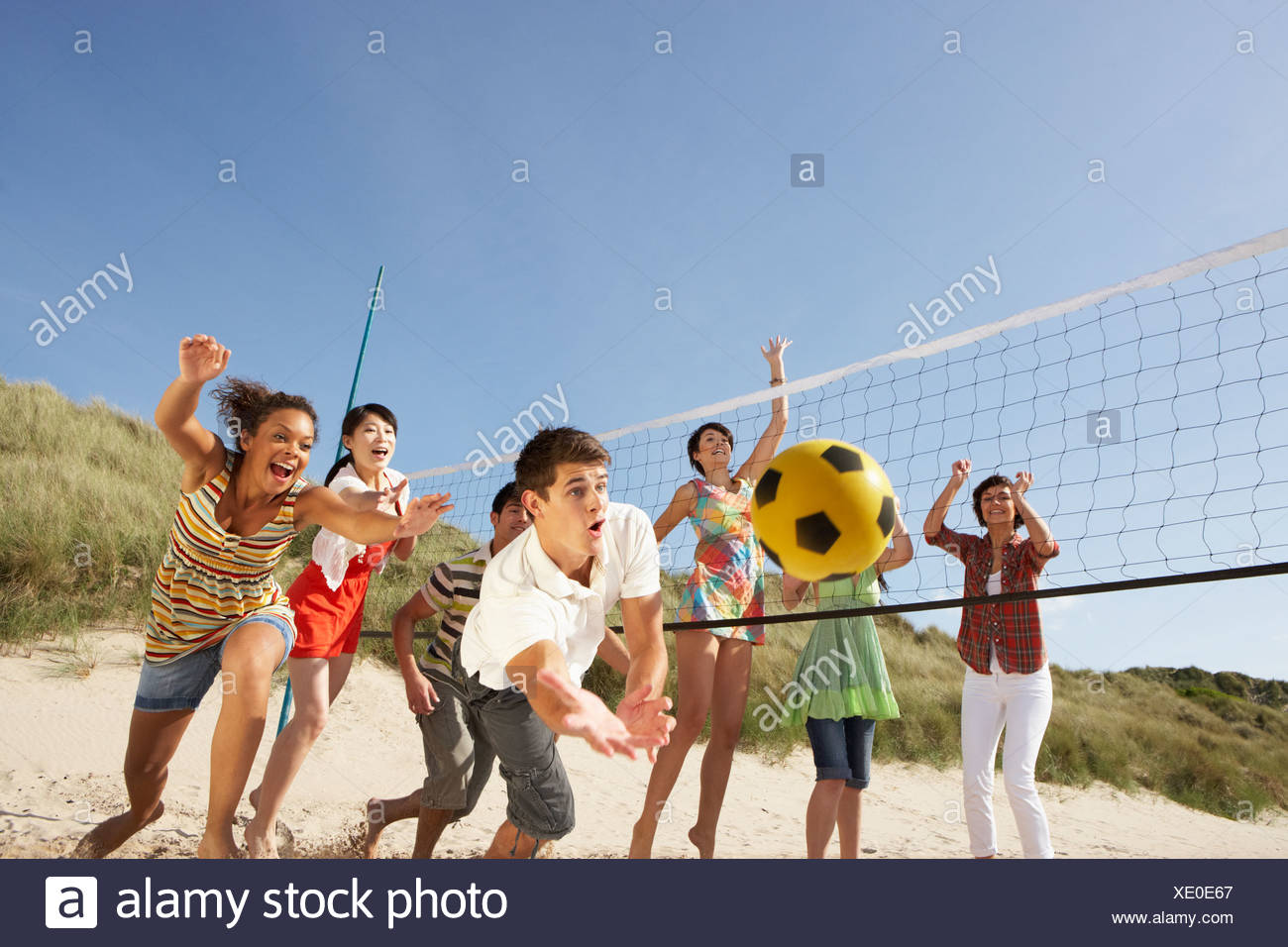 Friends Playing Beach Volleyball Together High Resolution Stock ...