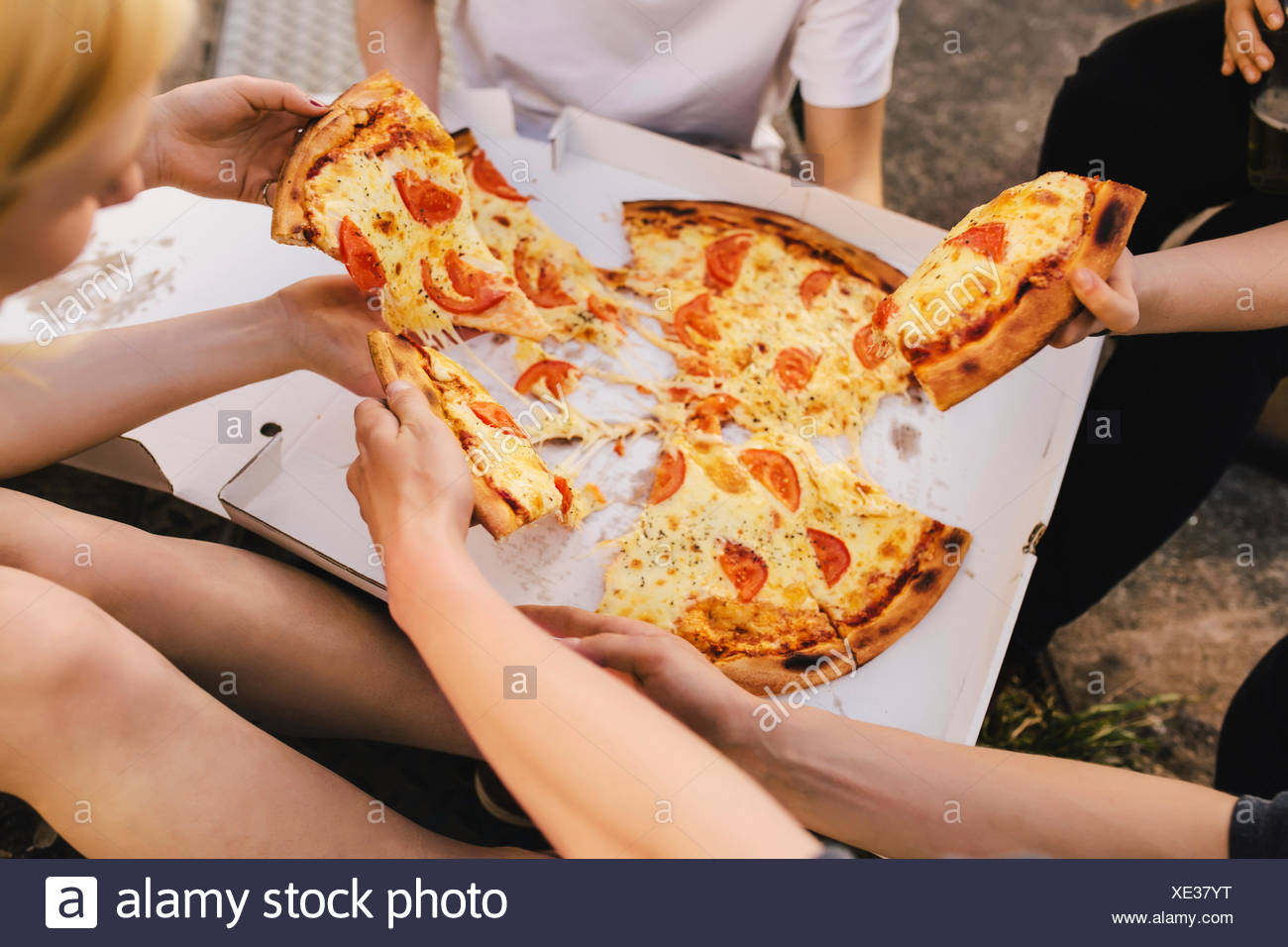Four Friends Sharing Pizza High Resolution Stock Photography and Images ...