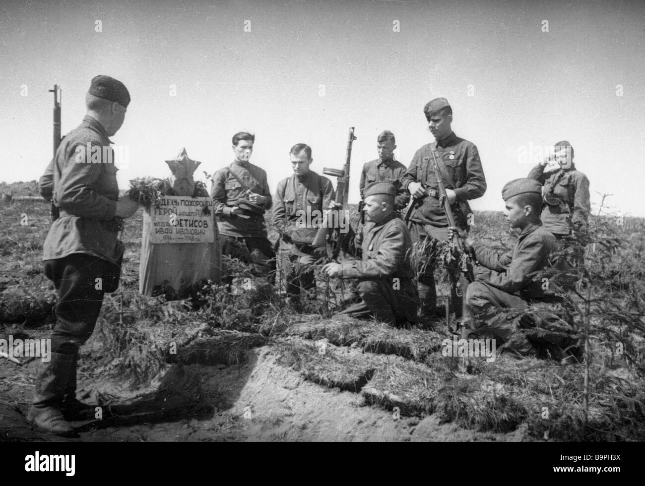 Red Army soldiers standing near the grave of their fallen comrade Stock ...
