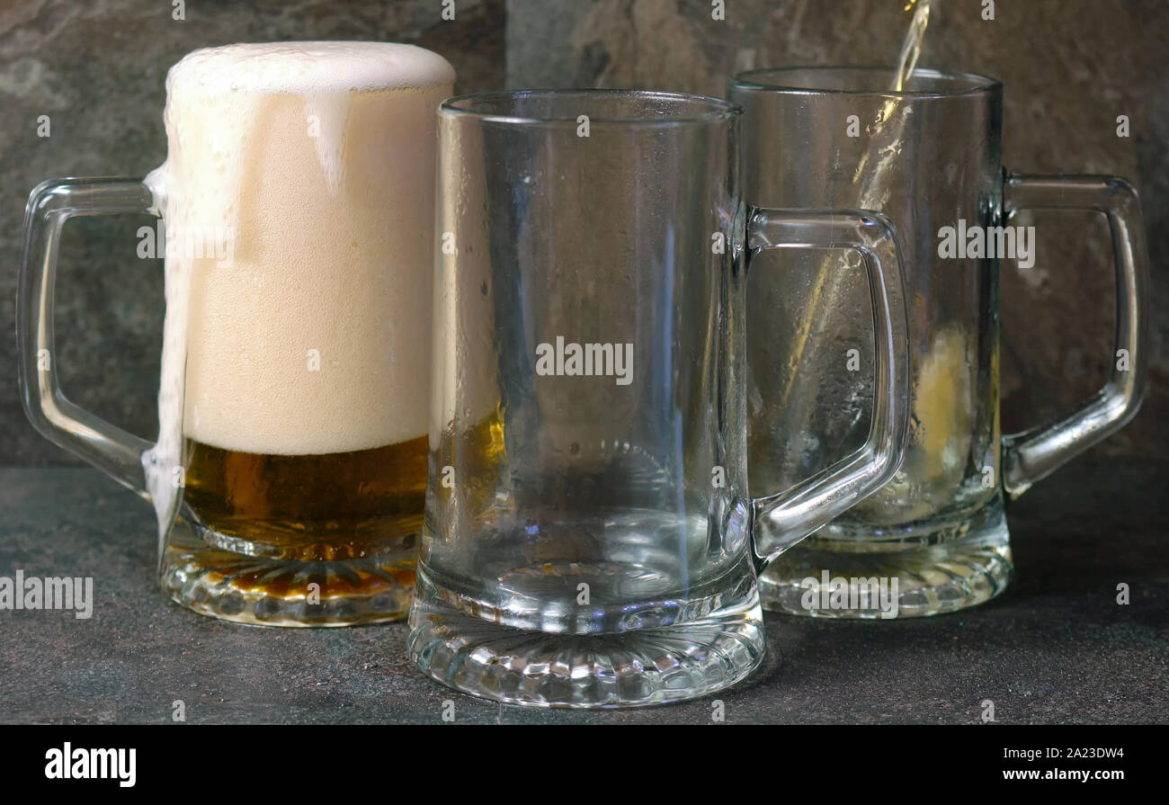 Bier zapfen in die traditionelle Bierkrügen auf schwarzem Schiefer bar ...