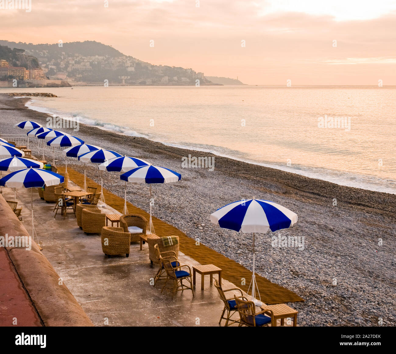 Blaue und weiße Sonnenschirme am Strand an der Baie des Anges in Nizza ...