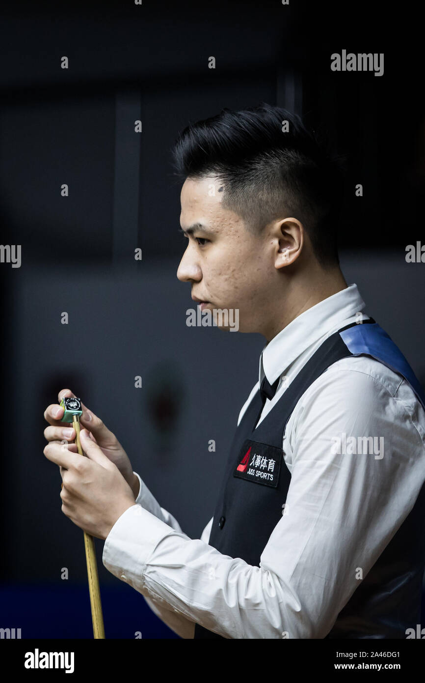 Xiao Guodong von China Kreiden seine Cue beim Betrachten einen Schuß zu ...