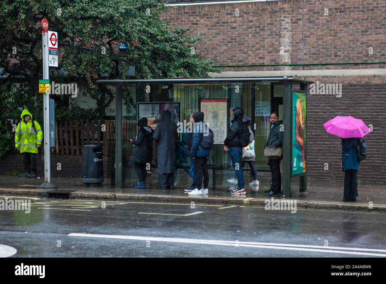 Menschen stehen im Regen auf einen Bus Top in London Stockfotografie ...
