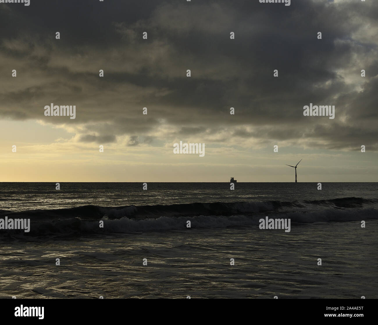 Strand mit Wellen in der Morgendämmerung, bewölkter Himmel und marine ...