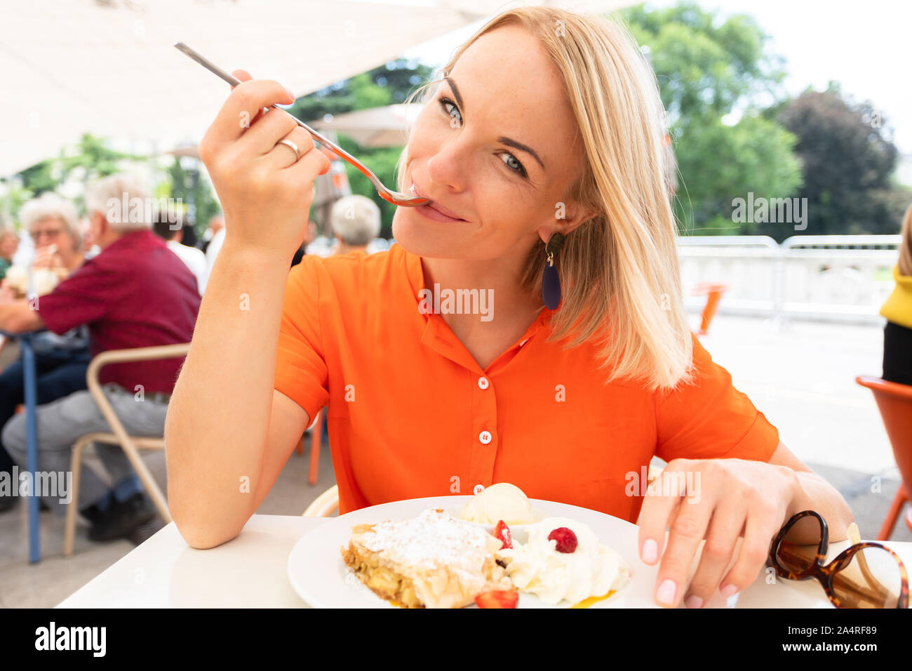 Junge Frau sitzt in einem Cafe in Wien und frisst Österreichs ...