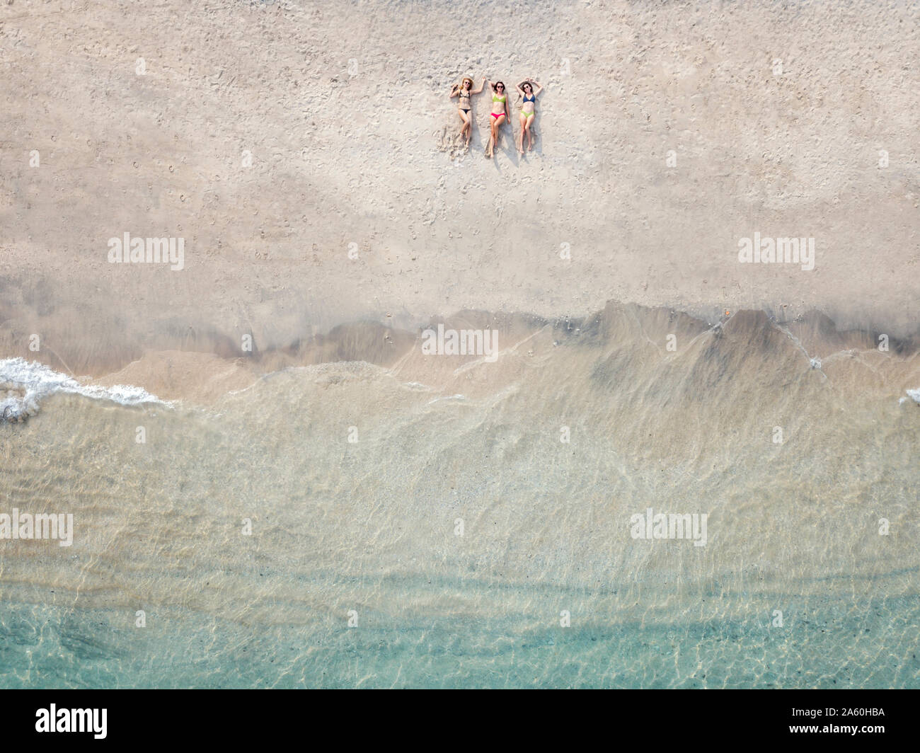Luftaufnahme von jungen Frauen am Strand liegend, Gili Air Island, Bali ...