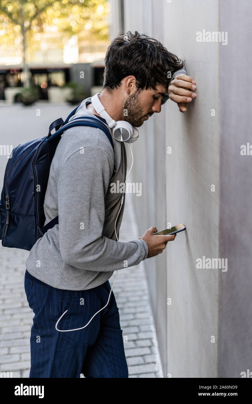 Mann lehnt an wand mit handy -Fotos und -Bildmaterial in hoher ...