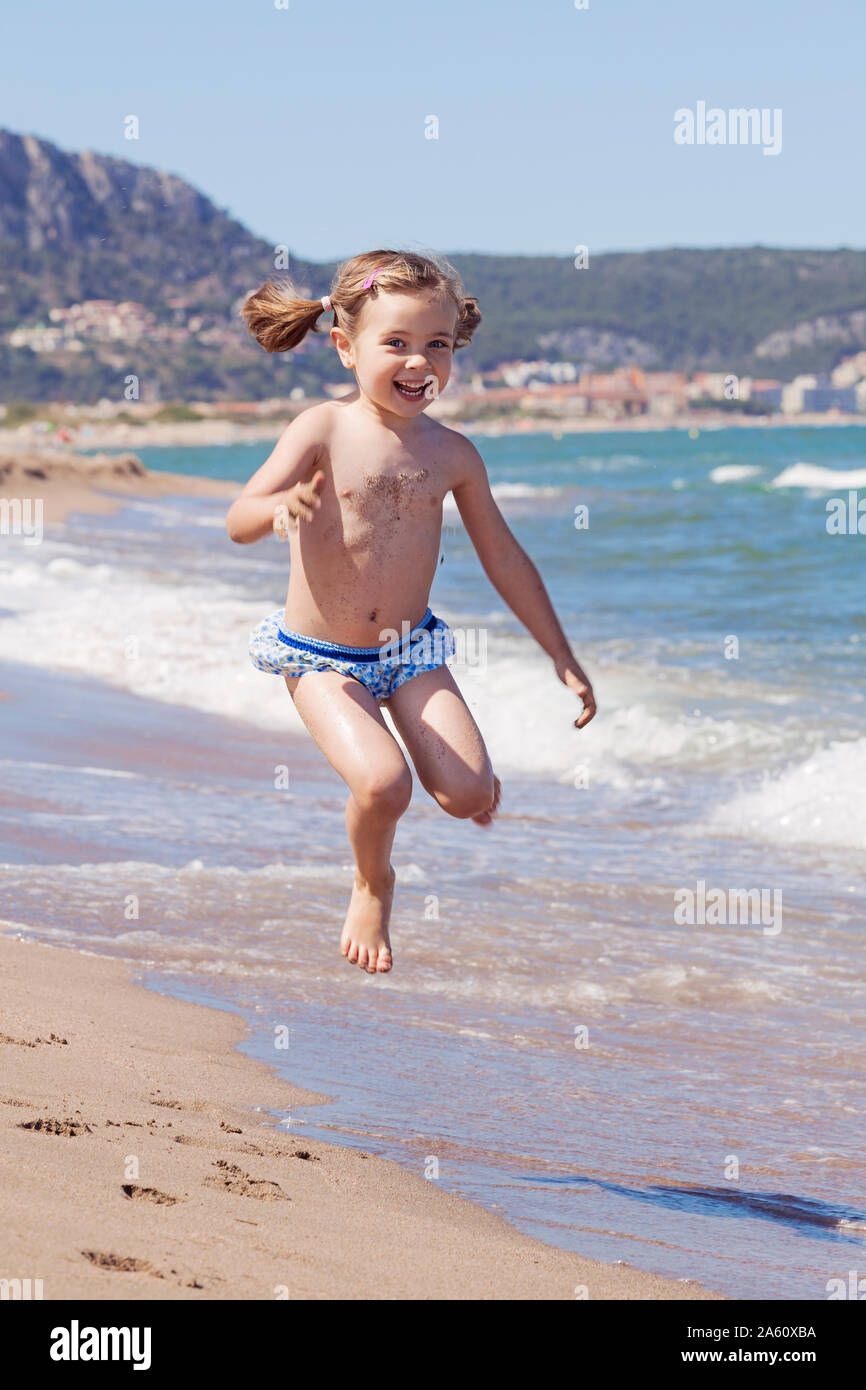 Happy little girl jumping in air on beach -Fotos und -Bildmaterial in hoher Auflösung – Alamy