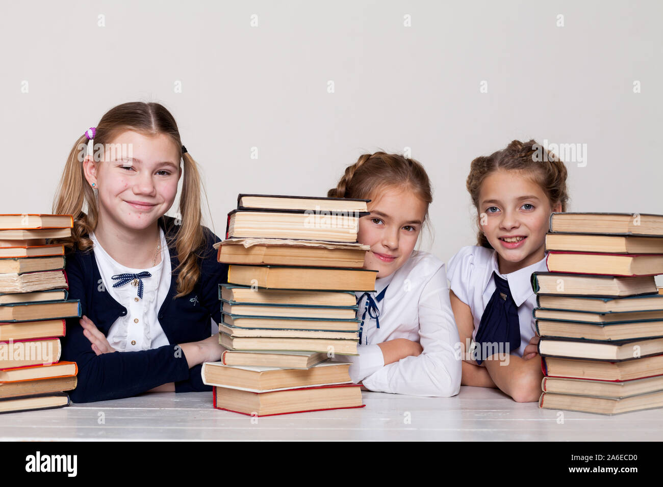 Drei Mädchen in der Klasse in der Schule mit einer Menge Bücher ...
