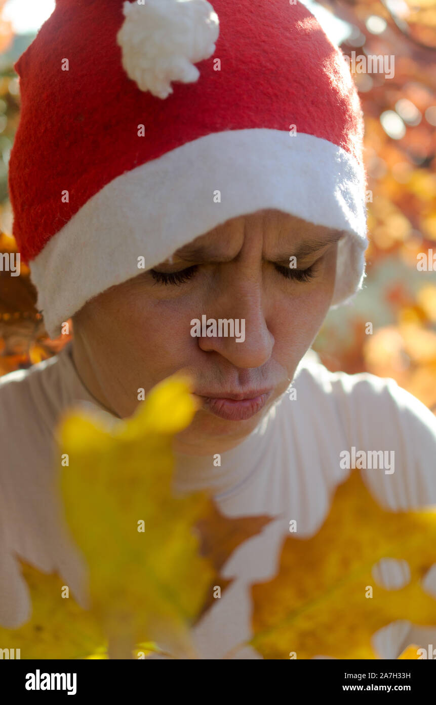 Eine Frau in einem Hut von Santaclaus mit einem schlauen böse Gesicht ...